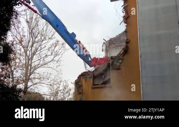 Destroying a structure using a mechanical shovel at a building house ...