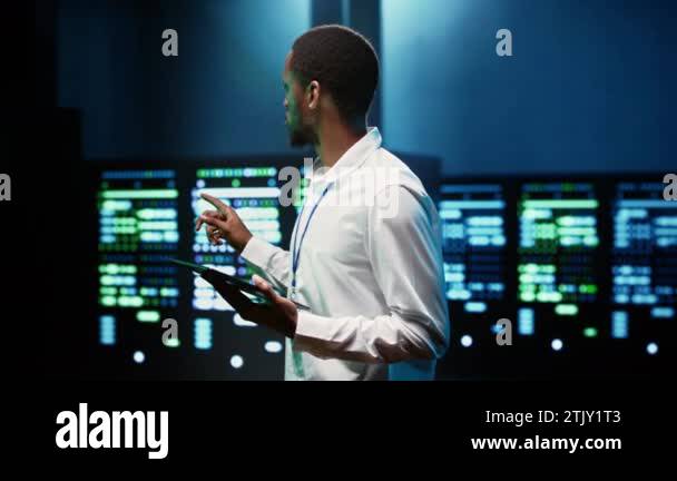 African american supervisor in server farm using tablet to find ...