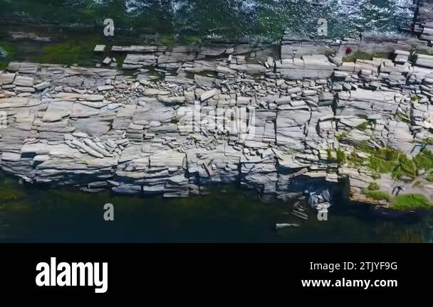 Video of Aerial pan looking down on rocky coastline with waves crashing ...