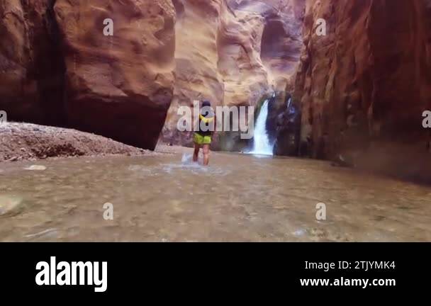Female tourist walk in water in famous river canyon of Wadi Mujib in ...