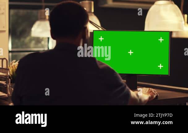 Successful Office Worker Analyzing Computer With Greenscreen Looking At Chroma Key Display At
