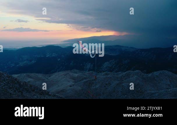 Broken and torn apart wind sock on pole, fly in strong wind on top of ...