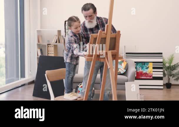 Close up view of senior grandfather and little child in similar outfits ...