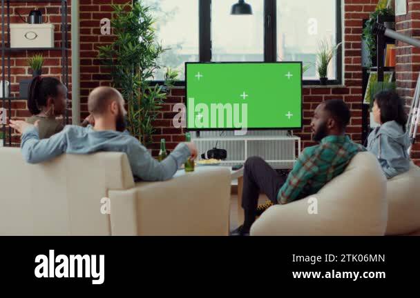 Group of people enjoying movie on television with greenscreen template ...