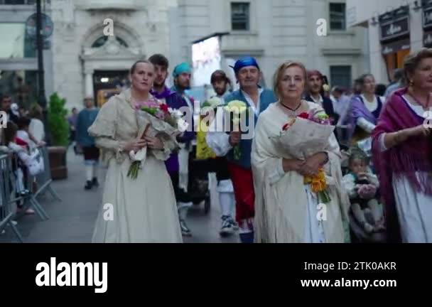 Group of Spaniards in traditional costume look at the camera and smile ...