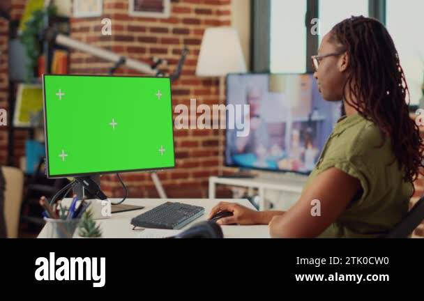 Corporate worker looking at greenscreen display on computer, working ...