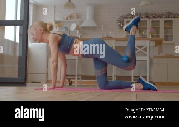 Active sporty fit attractive senior woman practicing cross training ...