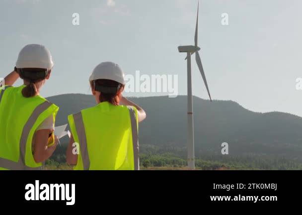 As energy researchers, two women engineers analyze and compare data on ...