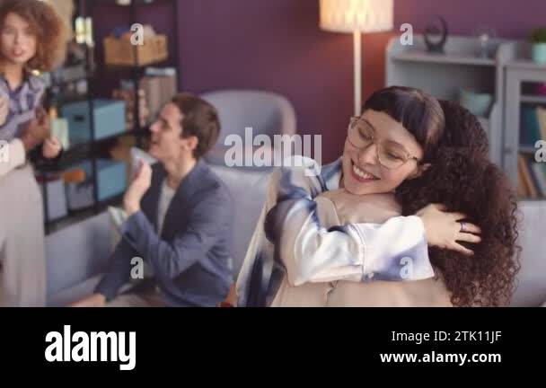 Two young beautiful women greeting and embracing each other when ...