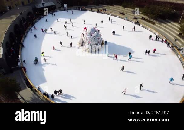 People skating on white ice skating rink outdoors on sunny winter day ...
