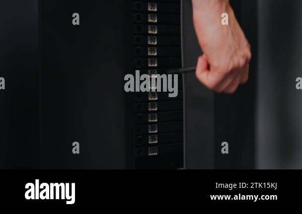 Hand weights, Weight stack, Machine adjustment. Mans hand is seen ...