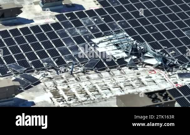 Broken down photovoltaic solar panels destroyed by hurricane Ian winds mounted on industrial ...