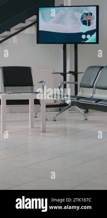 Vertical video: Empty hospital reception space with waiting room chairs ...
