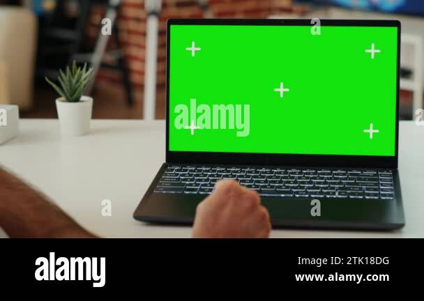 Young adult analyzing greenscreen display on personal computer, looking ...