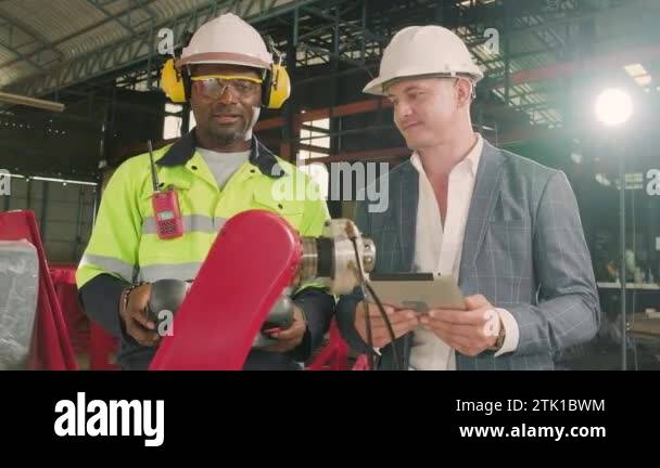An African American engineer demonstrates smart robotic arm control to ...