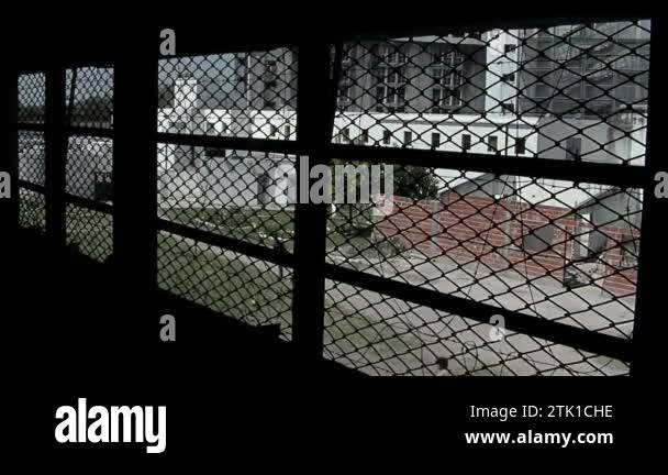 Window of a Prison Cell and Inmates playing Soccer at the Yard of Olmos ...