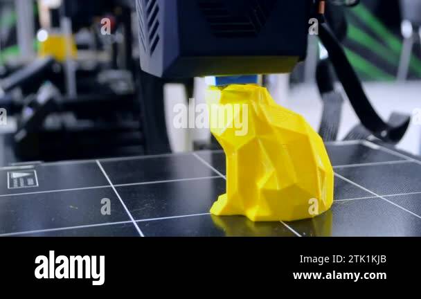 3D printer printing prototype of toy from molten plastic. Process of ...
