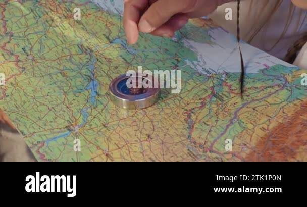 Close up of tourists looking at map, using compass, searching route ...
