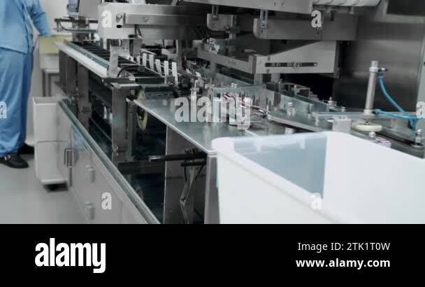 Manufacturing line at medical factory. Robotic arm put medicine package ...