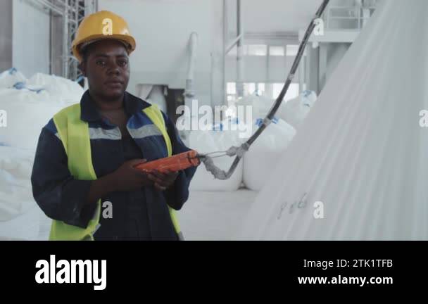 African American female factory worker wearing uniform holding lifting ...