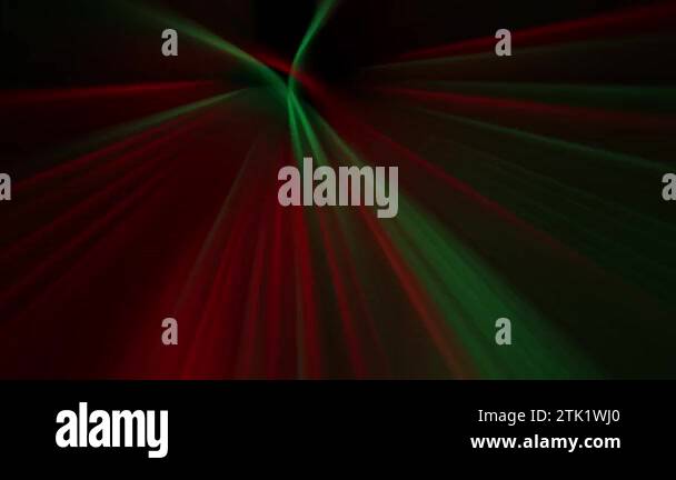 Green and red flashing beams of light are moving against a dark ...