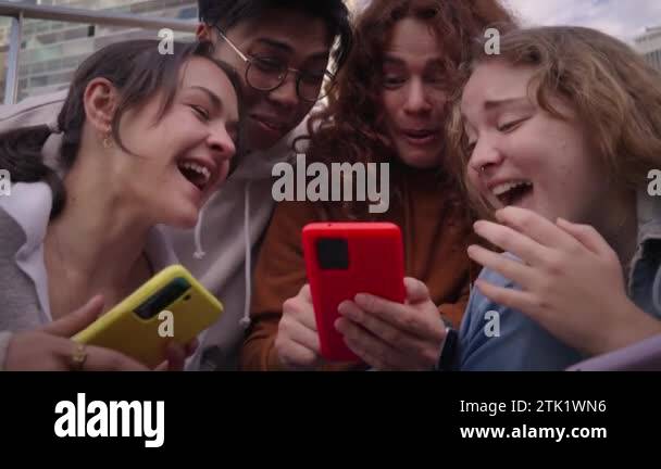 Group of multiracial classmate students looking at their smartphones ...