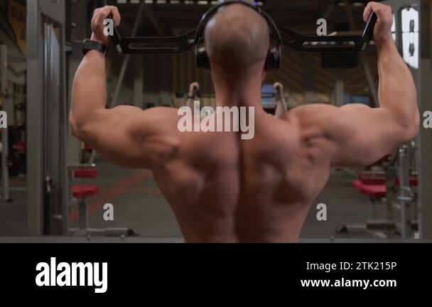 Athletic faceless bald man doing an exercise for the back muscles in ...