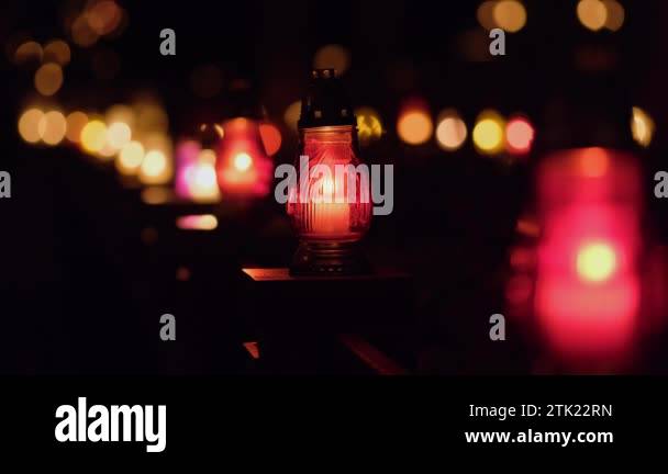 Candle lights on graves and tombstones at a cemetery in Poland during All Saints Day, Zaduszki ...