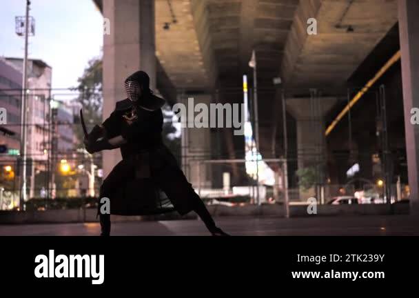 Man clad in kendo uniform performs powerful strikes with his gleaming ...