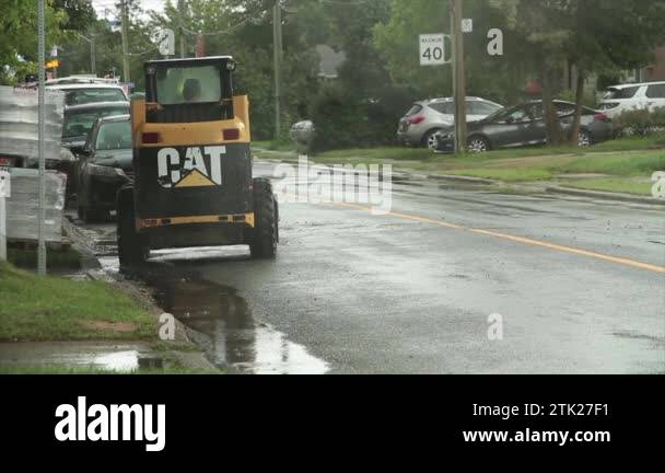 bobcat parked at side of wet road, reverses and pulls into driveway ...