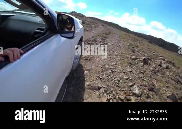 Drive an SUV through the hills of the mountains. A white car drives ...