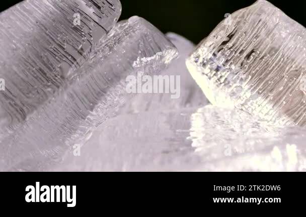 Pieces of ice with frozen air bubbles shine through with light. Frozen ...