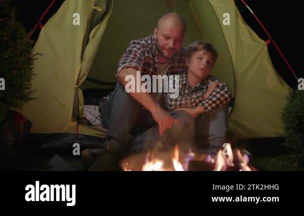 Dad and Son Talking Sitting on Tent by the Fire. Family camping evening ...