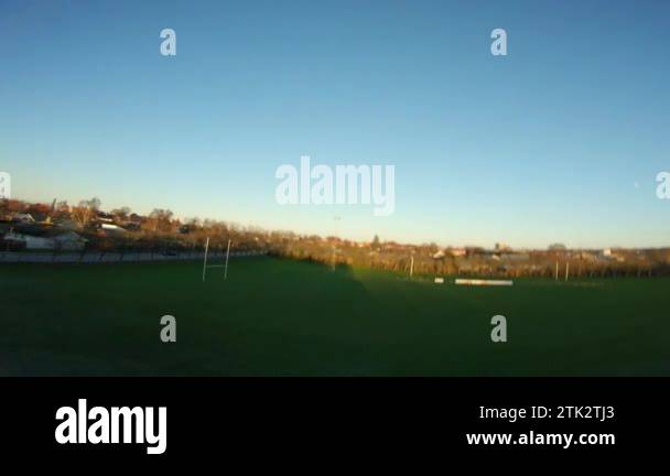 Race drone flies fast and low through the fences and structures of a ...