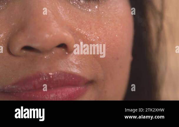 CLOSE UP: Sweat drops dripping down the beautiful face of a young woman in sauna. Detailed view ...