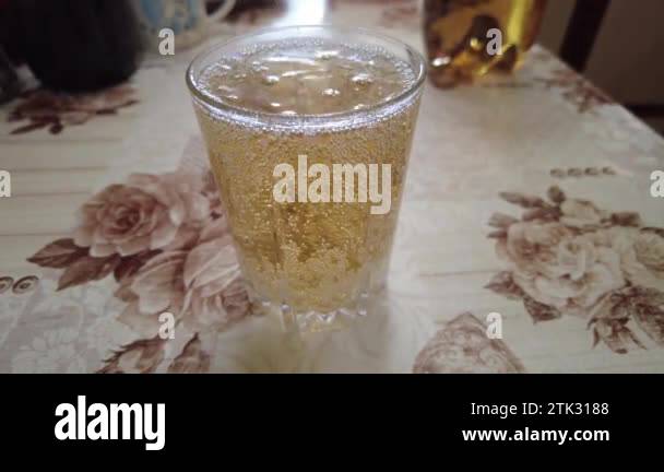 lemonade in a transparent glass. 4k footage. Pouring a carbonated drink into a glass close up ...