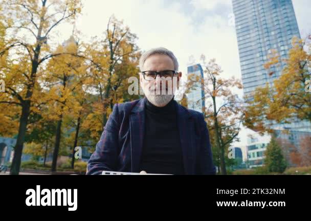 Camera zooming out the stylish, confident, bearded, grey-haired man ...