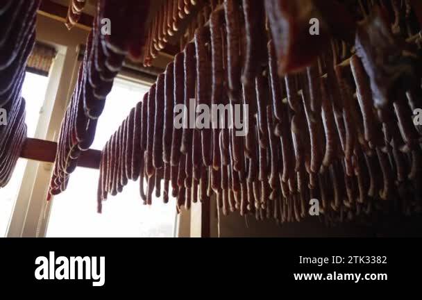 Close-up of raw pieces of pork, beef and bacon in a drying rack ...