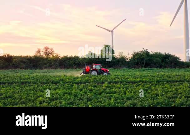 Zoom out span from drone of crop sprayer traktor spraying pesticide or ...