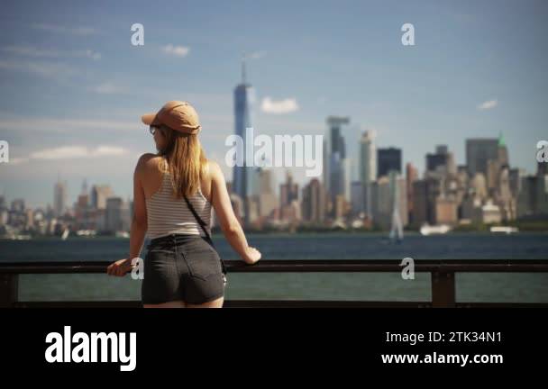 A video showing the back view of a woman standing in place and resting ...