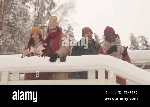 Four young multiethnic people having conversation while spending winter ...