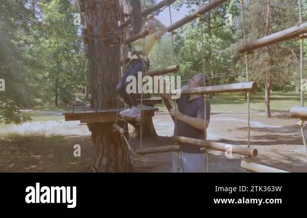 Child in a forest adventure park made of ropes. Children's outdoor ...