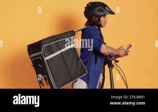 Handheld shot of rushing bike rider looking at phone, waiting to ...