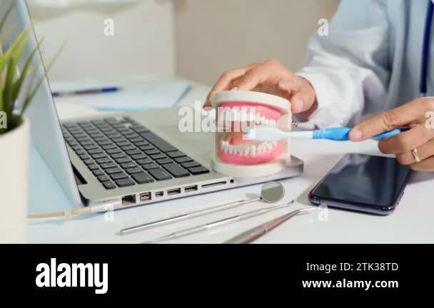 Dentist teaching explaining how to brush teeth correctly to patient ...