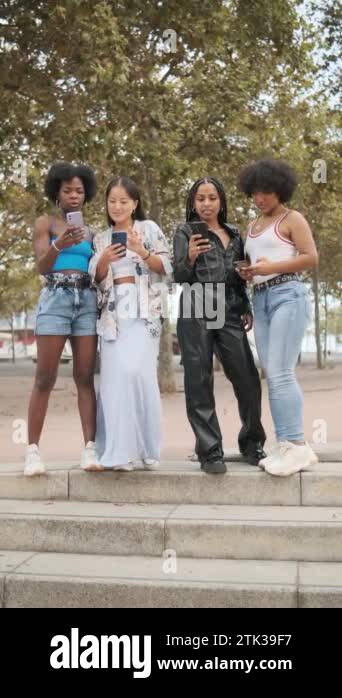 Vertical video in slow motion of transgender woman with friends using a ...