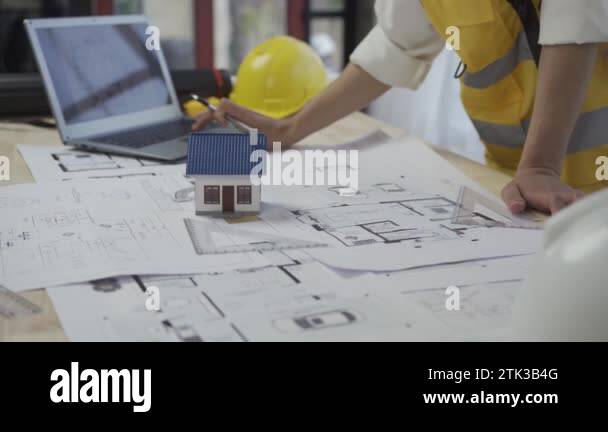 Team of engineers working together on blueprint plan at construction ...