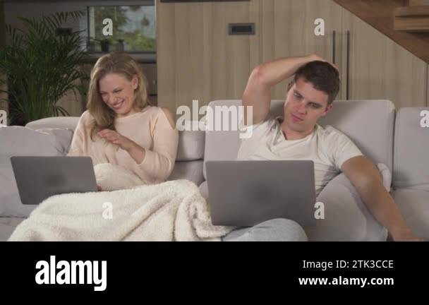 CLOSE UP: Guy being disrupted by his girl while they are both working from home. Couple handling ...