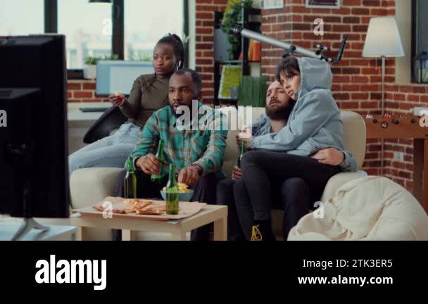 Multiethnic group of people getting scared watching horror film ...