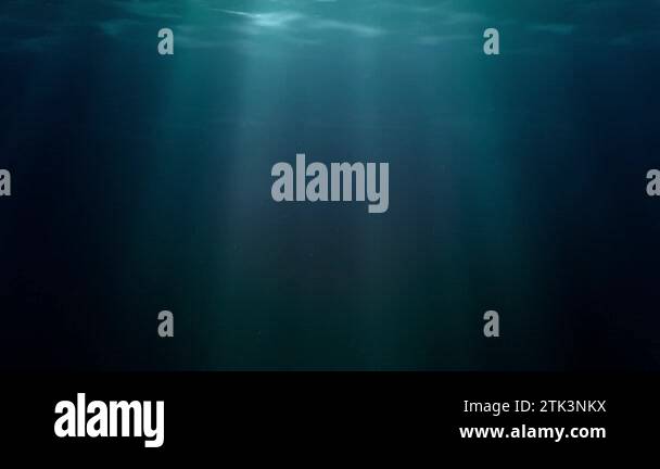 Sun light beams shining from above through deep clear blue water ...