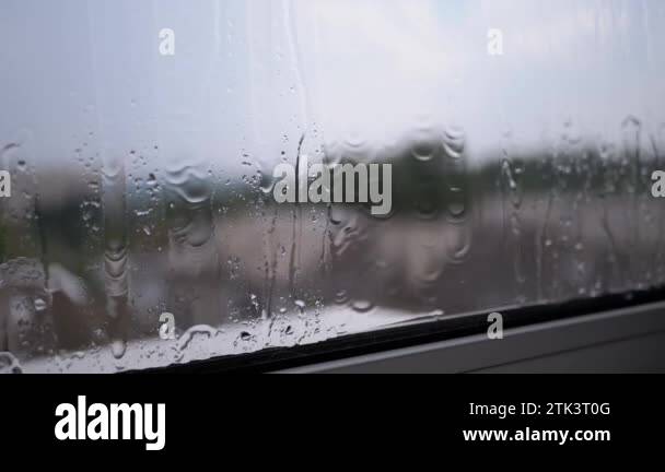 Stream of Rain Drops Flows Down the Wet Glass Outside the Window. Gloomy sky, rainy autumn ...